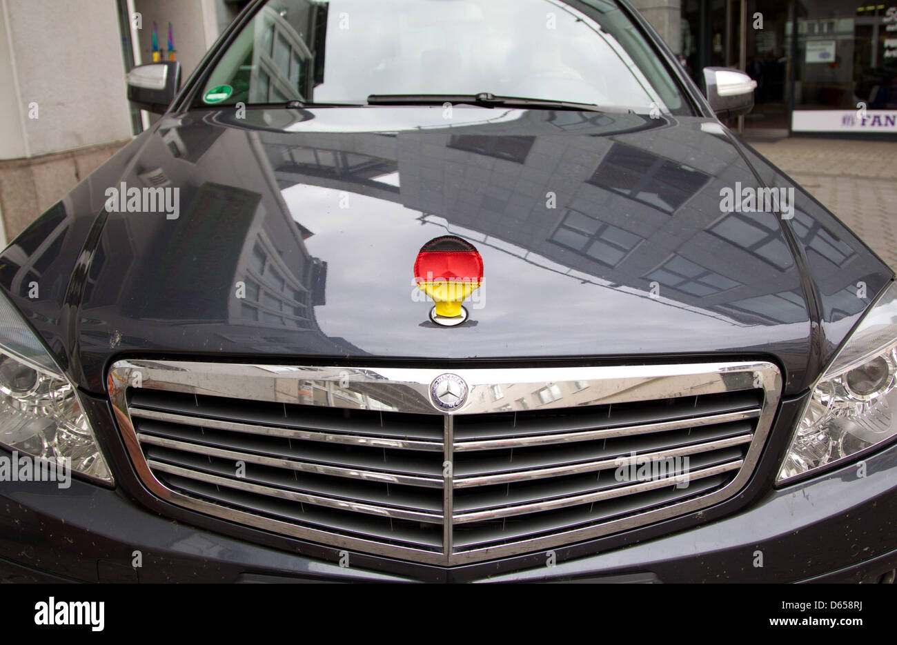 A mercedes is decorated with a German flag on the mercedes star in ...