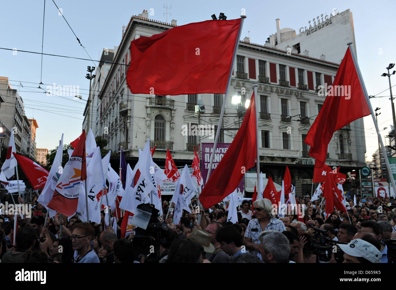 Supporters of the Greek SYRIZA party, wave flags during an election ...