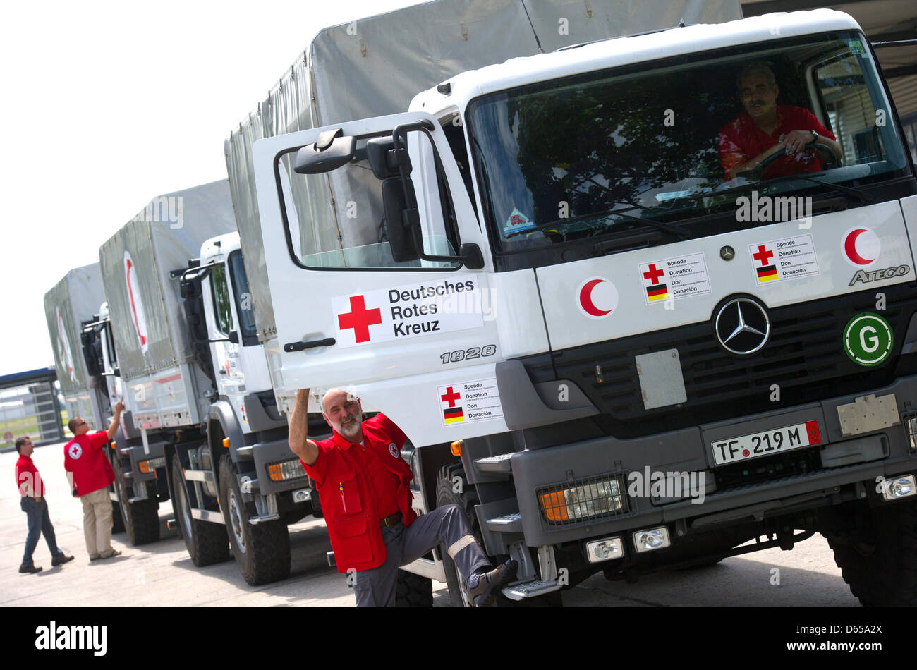 Helpers of the German Red Cross DRK prepare the transport of three ...
