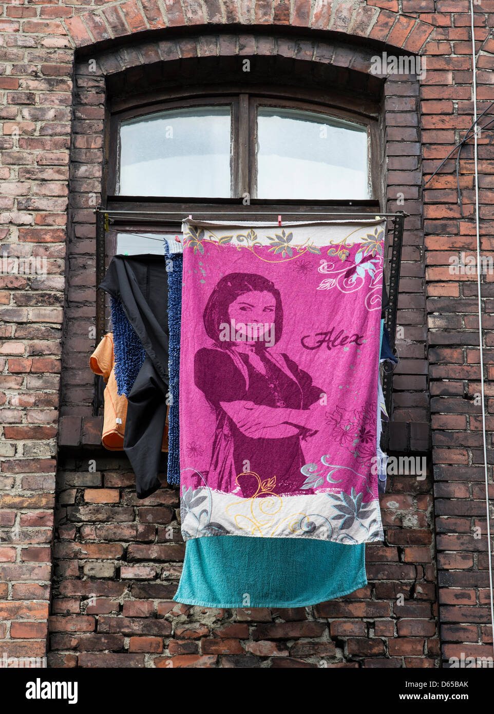 Clothes and towels are hug up to dry at a window of an apartment ...