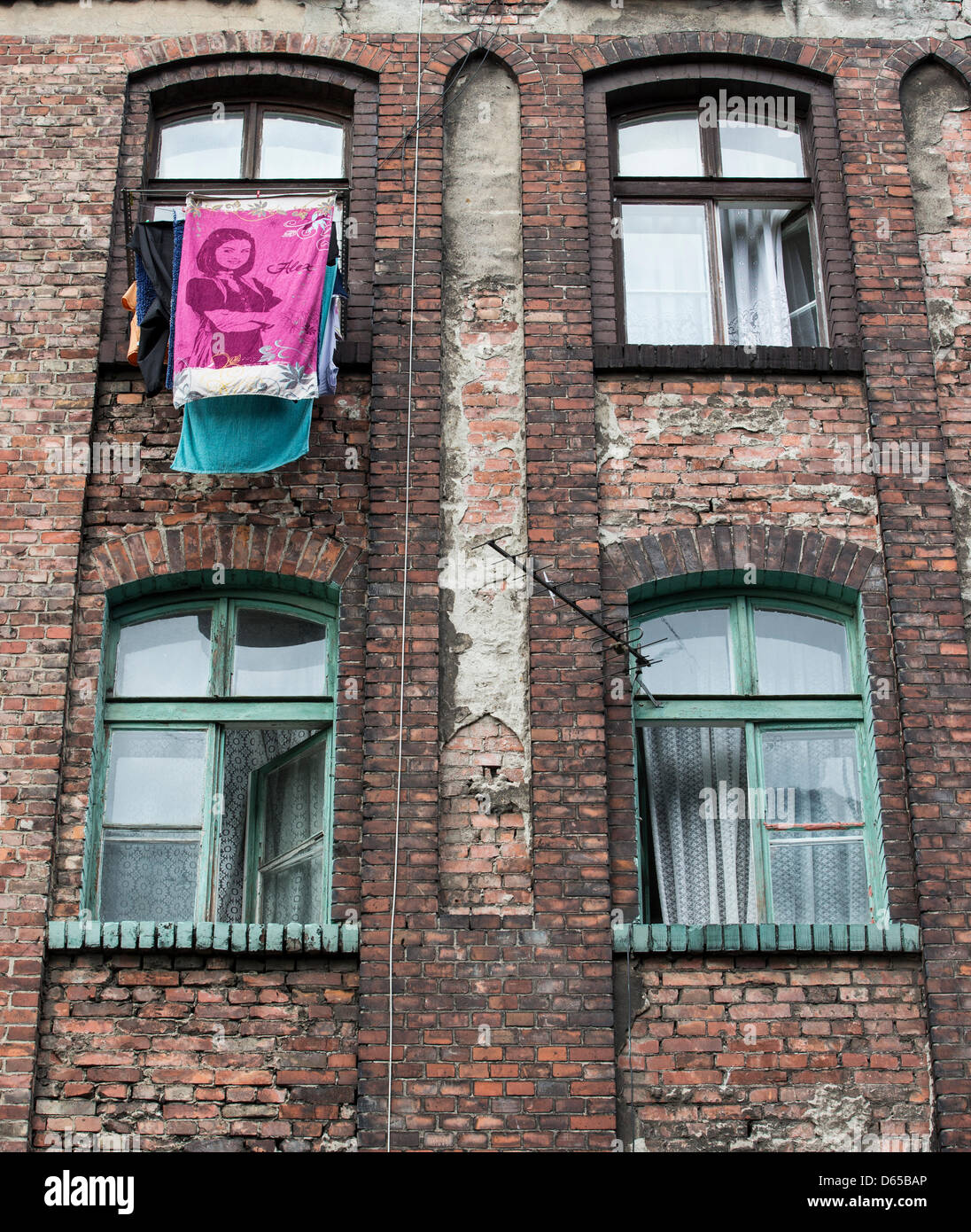 Clothes and towels are hug up to dry at a window of an apartment ...