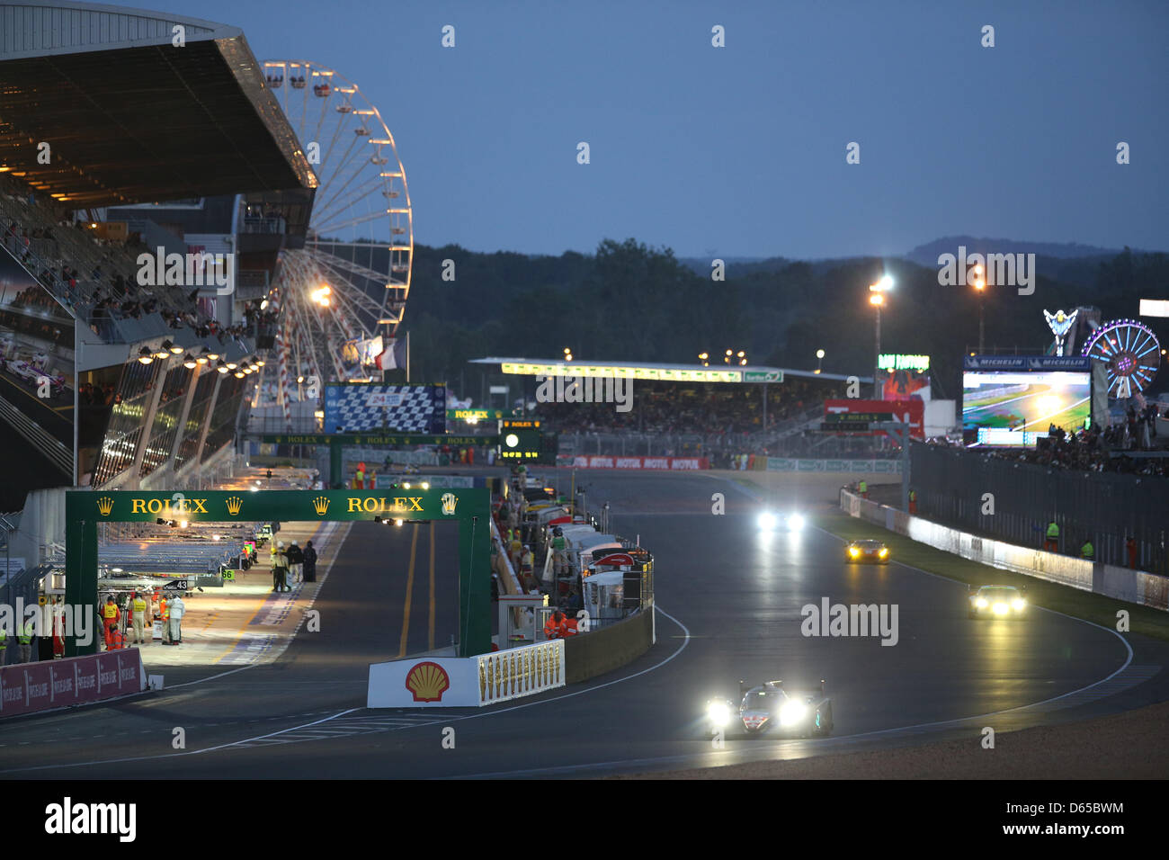 The cars are passing the start lane as night sets in during the 80th 24 ...