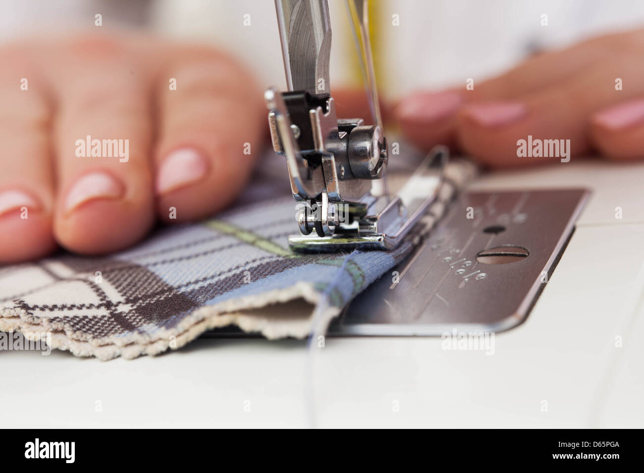 A sewer making a stitch on the fabric Stock Photo - Alamy