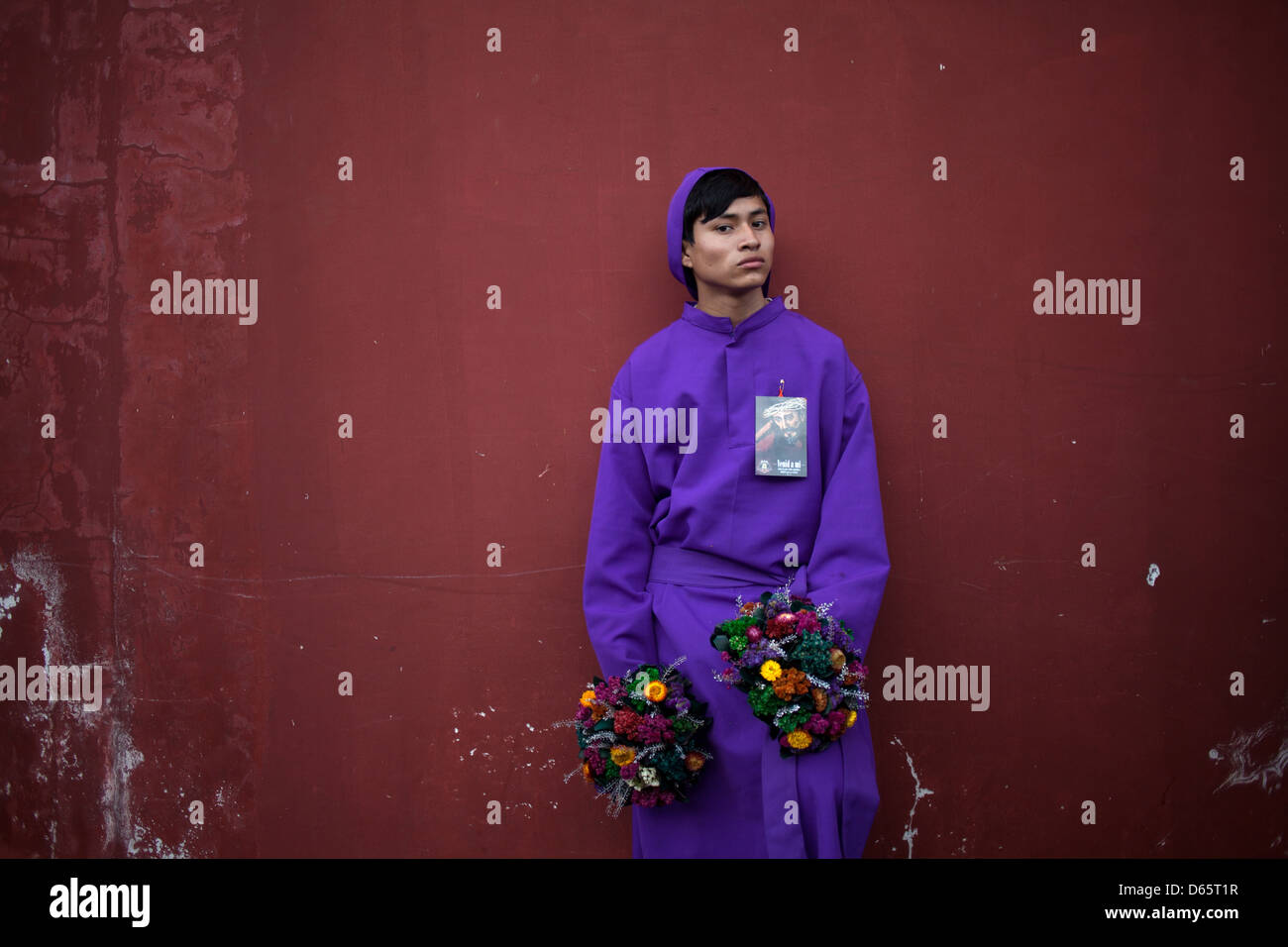 A penitent holds flower bouquets at the Jesus Nazareno del Perdon ...