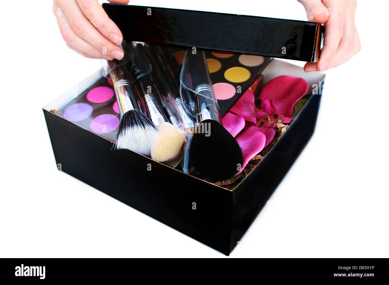 A Woman opening a gift box containing cosmetic brushes and makeup Stock ...