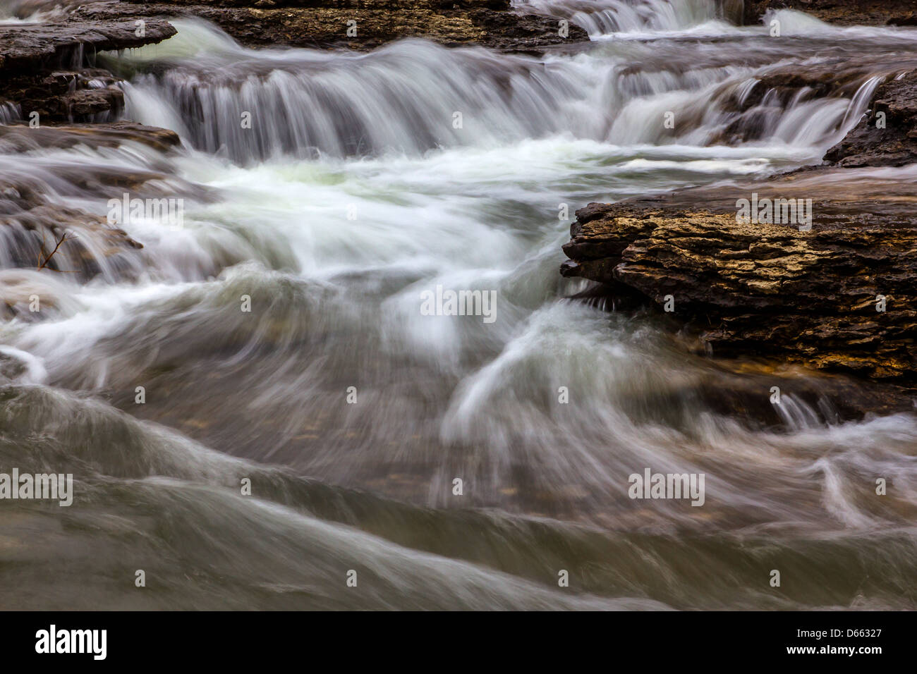 Rushing Water flows and breaks against rocks Stock Photo - Alamy