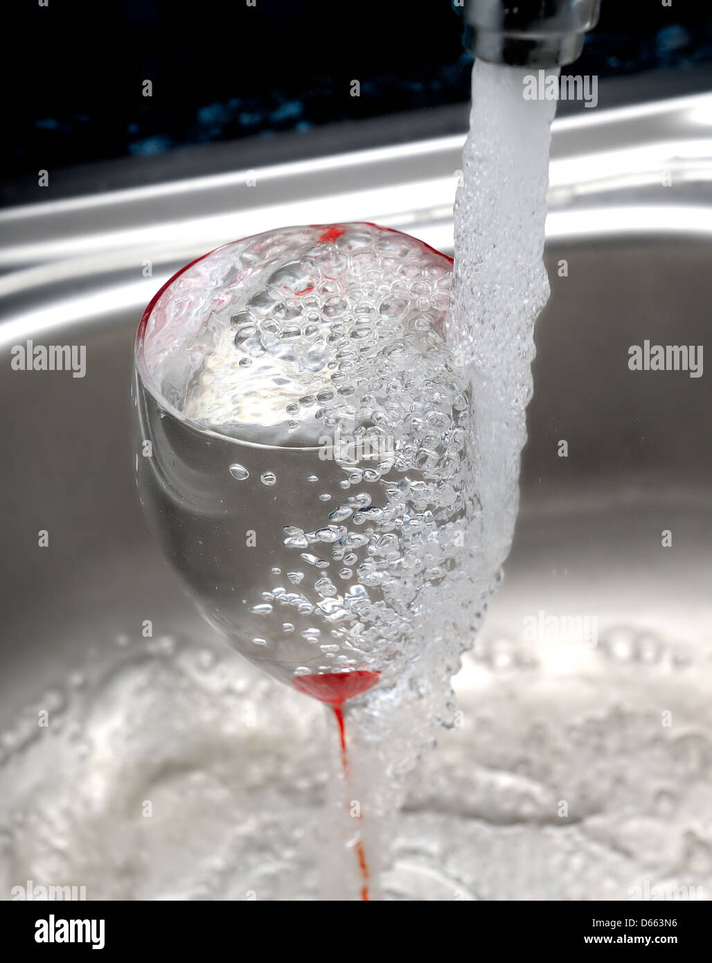A glass being rinsed under a tap Stock Photo - Alamy