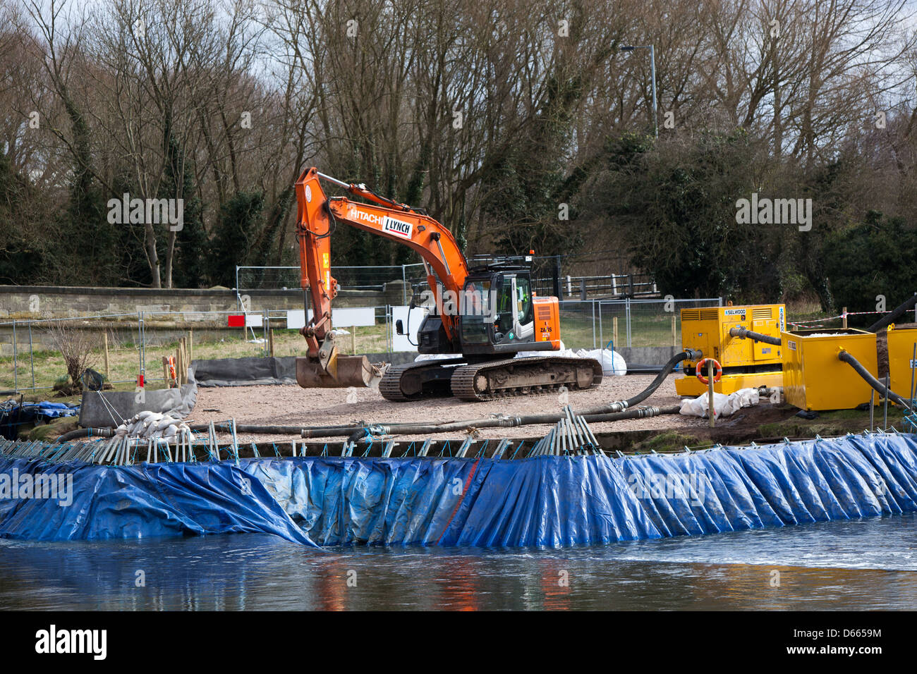 A mechanical digger working on a riverside construction project Stock ...