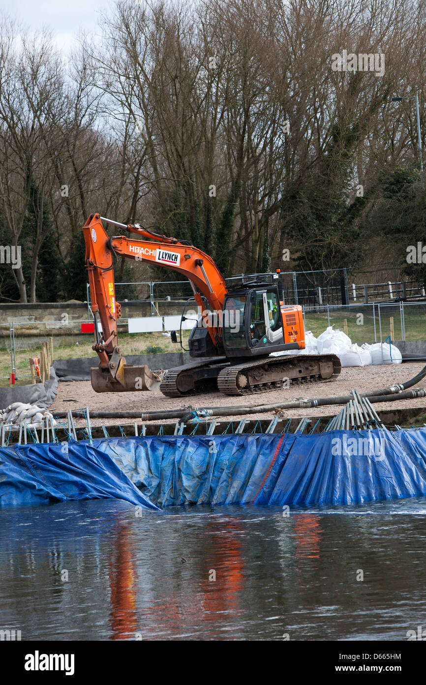 A mechanical digger working on a riverside construction project Stock ...