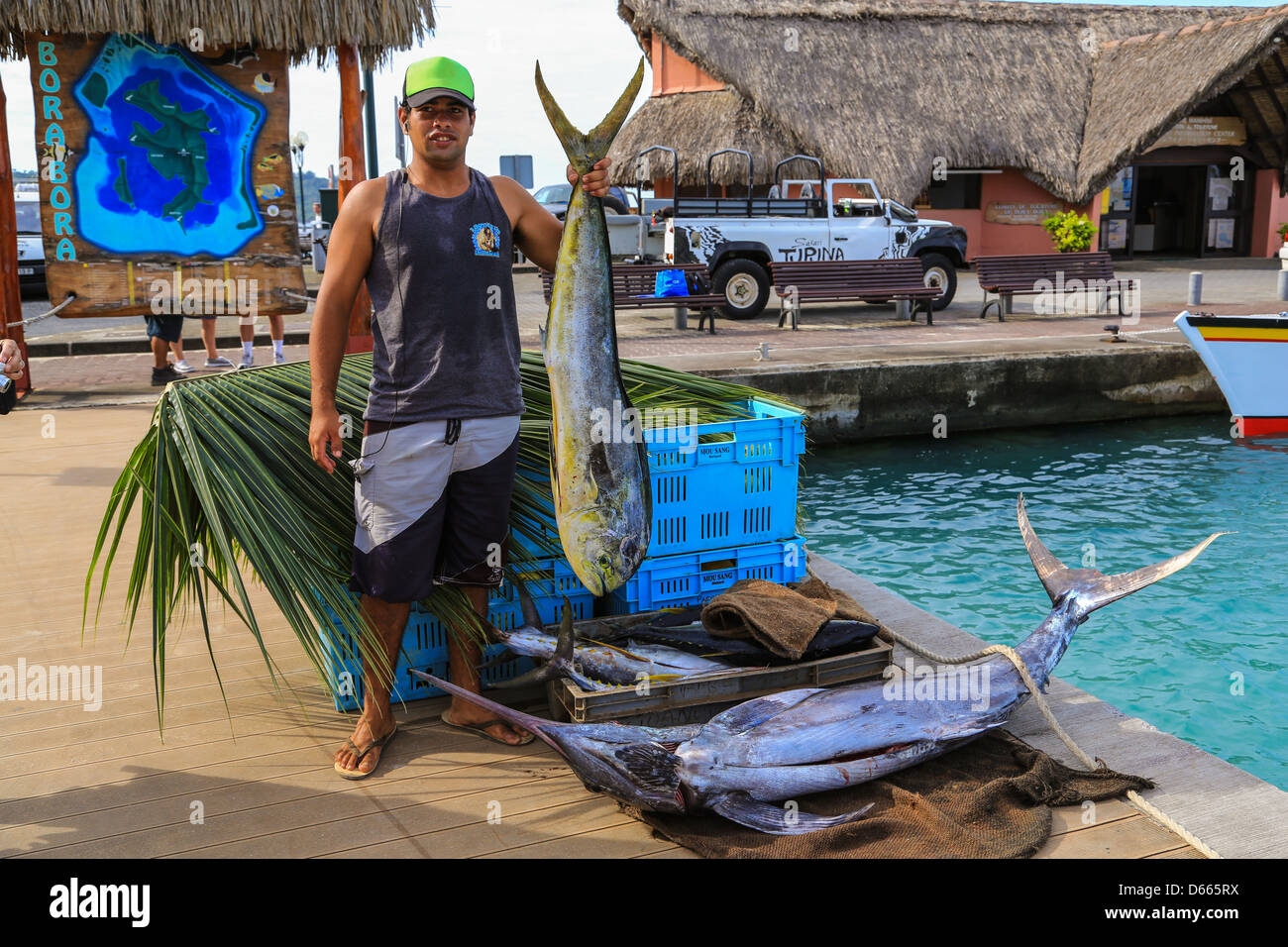 A man from a charter fishing boat at Bora Bora is holding up part of ...