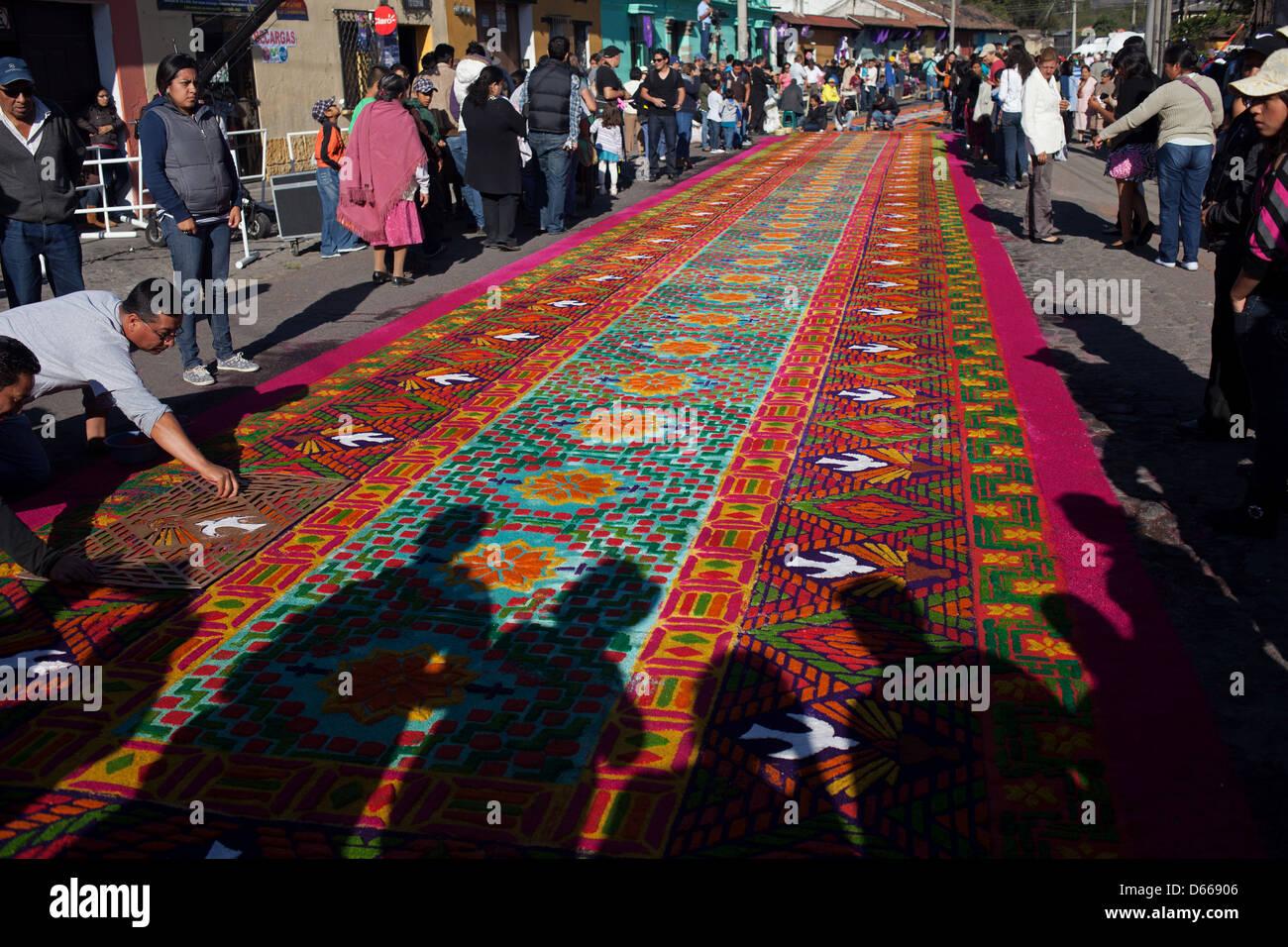 Tourists surround a colored sawdust carpet during Easter Holy Week ...