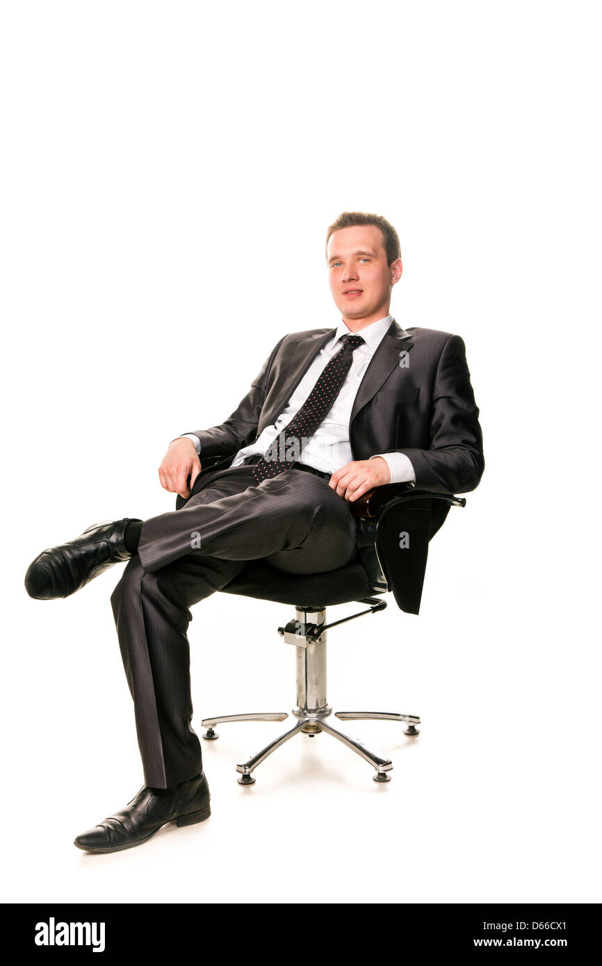 Confident smiling young businessman sitting on a chair isolated on ...