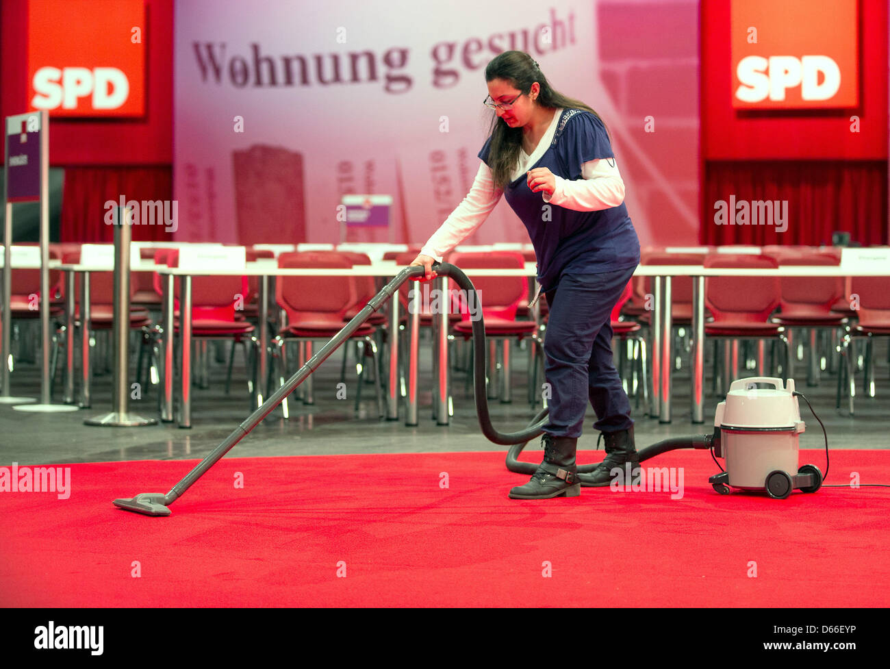 A cleaning woman hoovers the carpet of the meeting room in Augsburg ...