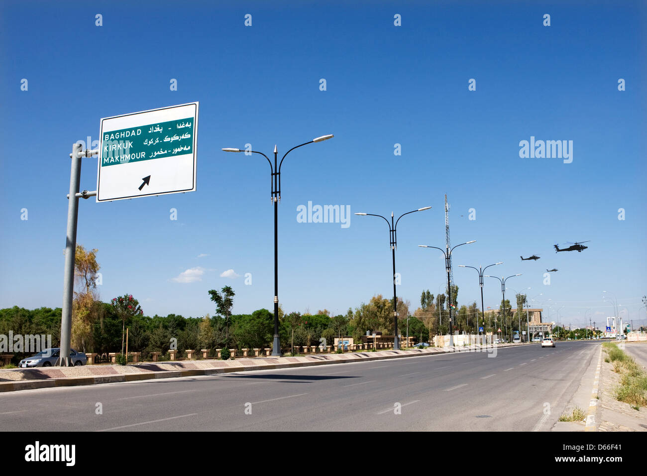 A street sign above a road pointing the direction to Baghdad and Kirkuk ...