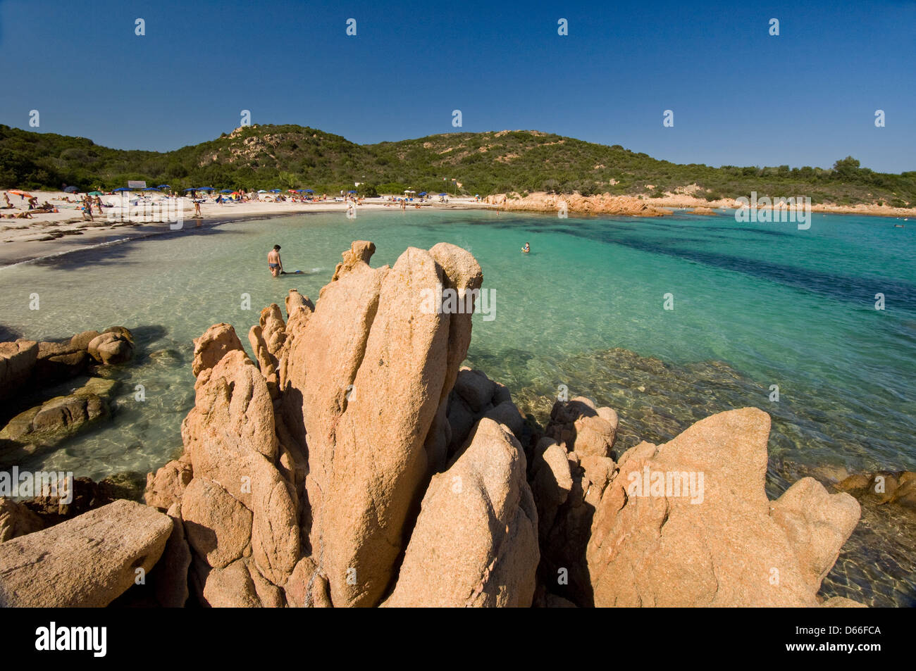 The Principe beach with tourists and granite rocks near Porto Cervo ...