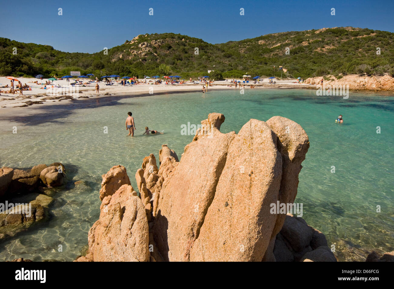 The Principe beach with tourists and granite rocks near Porto Cervo ...