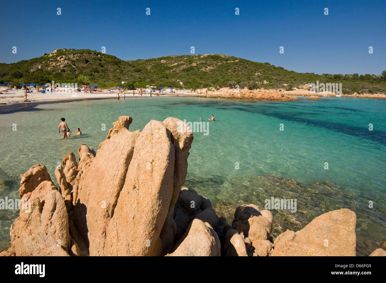 The Principe beach with tourists and granite rocks near Porto Cervo ...