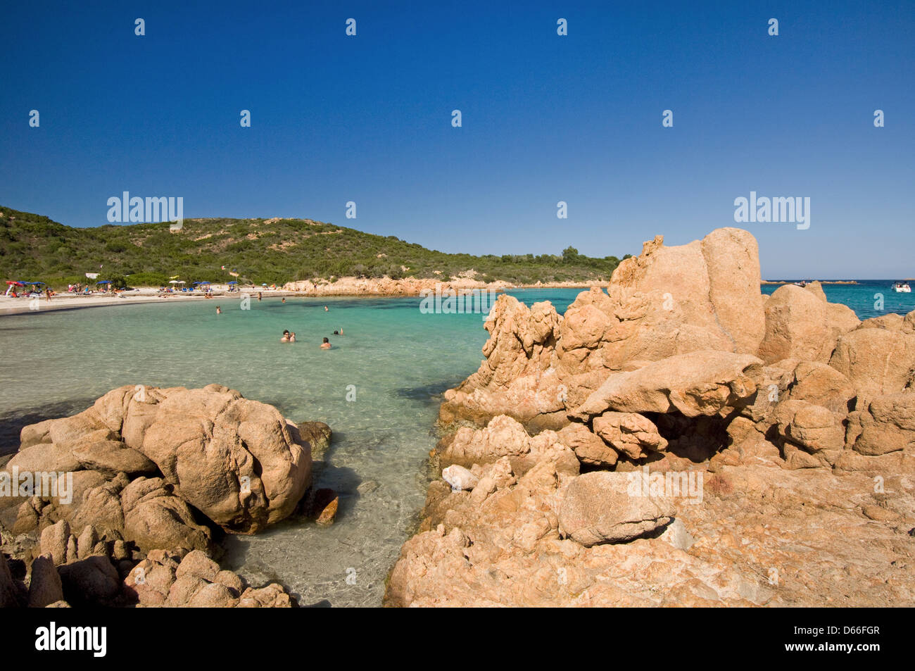 The Principe beach with tourists and granite rocks near Porto Cervo ...
