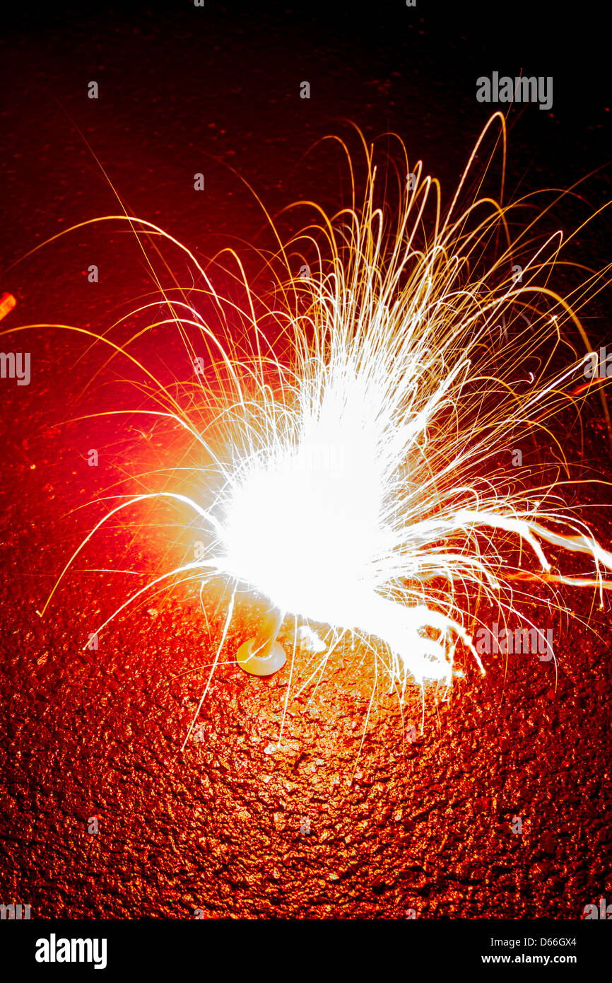a little bright red firework on the ground Stock Photo - Alamy