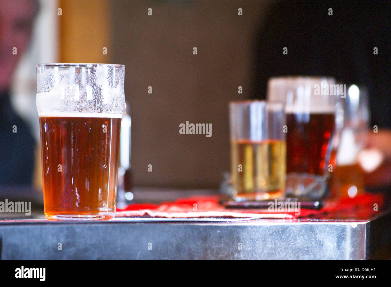Pints of beer, lager and bitter on a bar pub table drinks glasses Stock ...