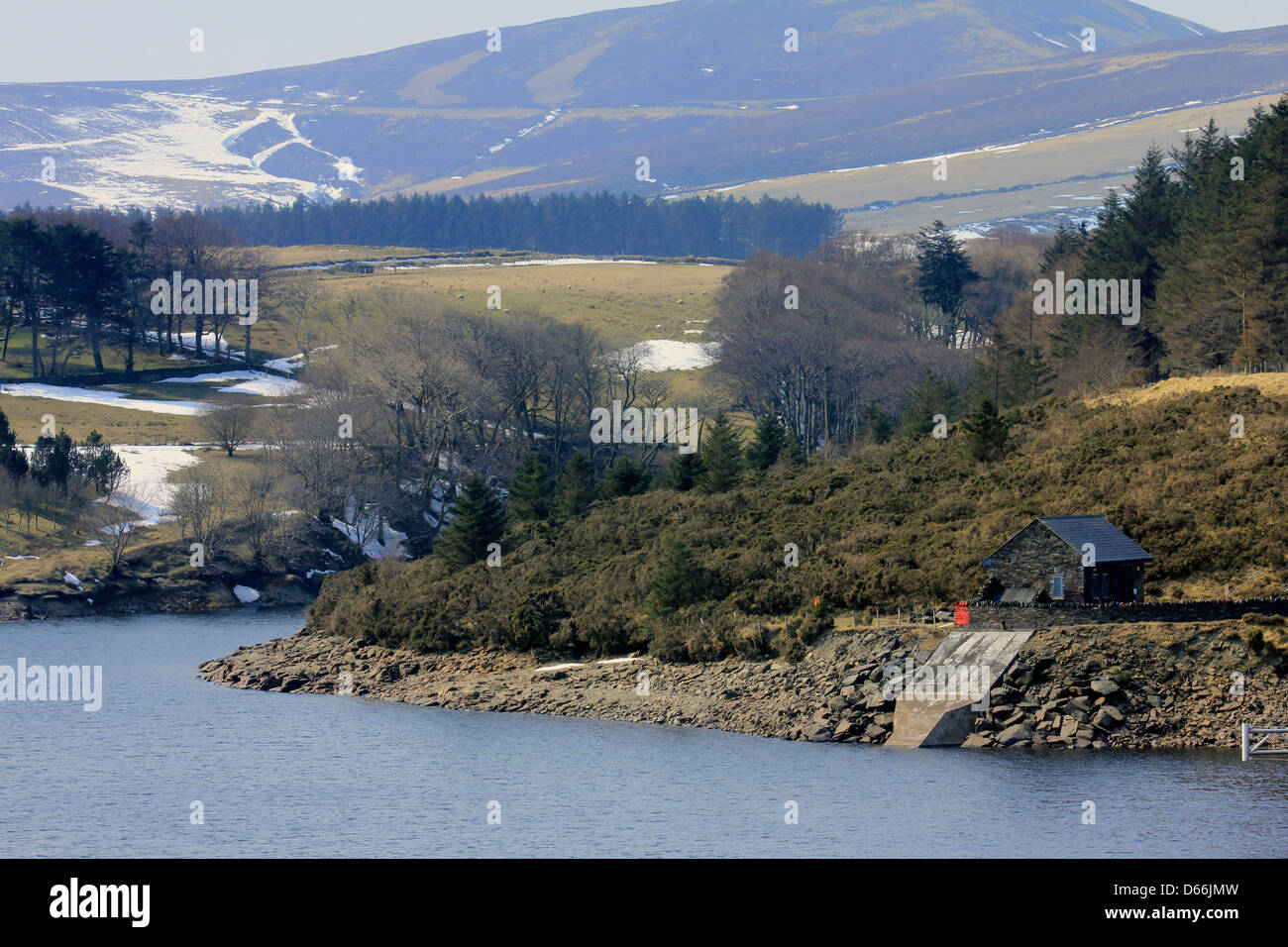 Wintry landscape of a reservoir amongst the wooded hills in Sulby the ...