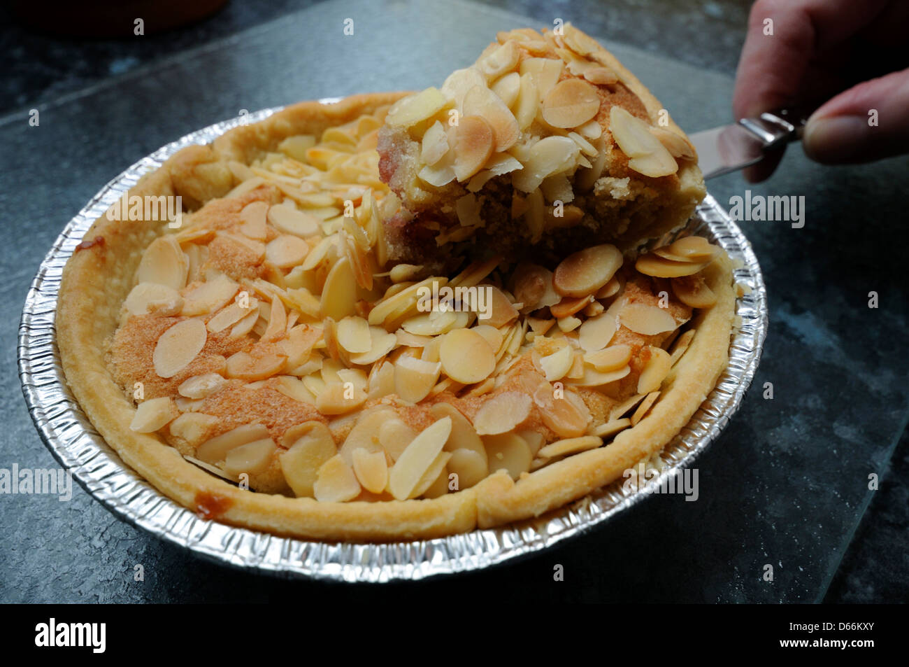 Traditional Bakewell Tart with a slice being cut out Stock Photo - Alamy