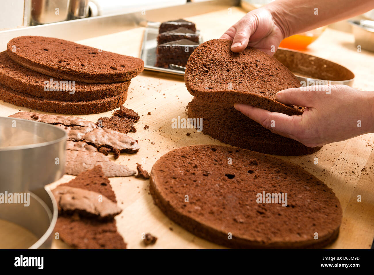 Chef cutting chocolate cake layers and stacking them Stock Photo - Alamy