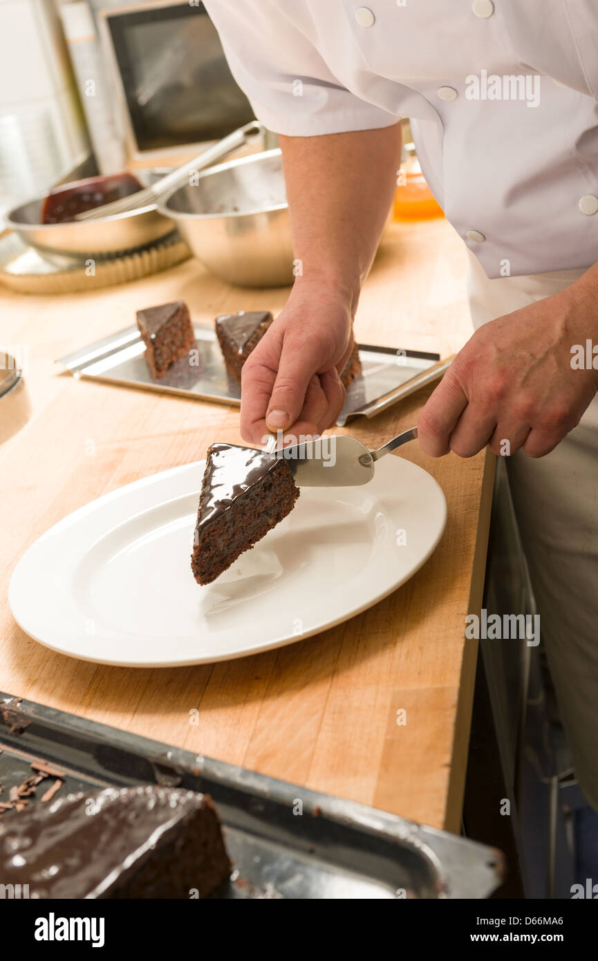 Chef placing slice of cake to plate with cake server Stock Photo - Alamy