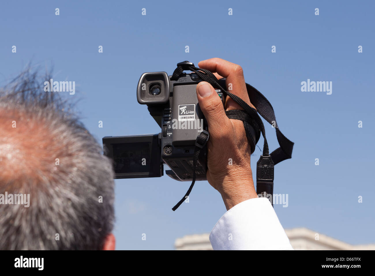 Man holding up a video camera Stock Photo - Alamy