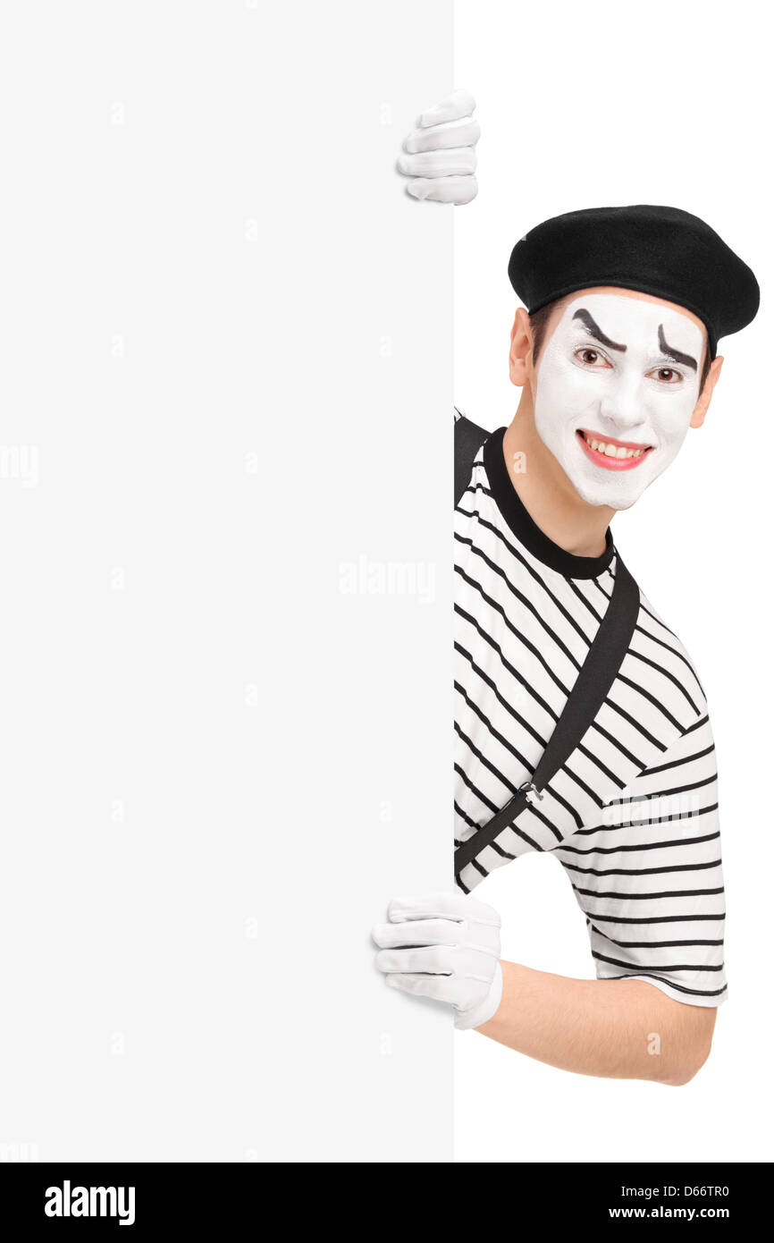 Smiling mime artist posing behind a blank panel, isolated on white ...