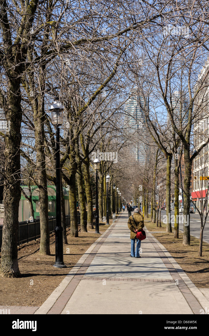 Man walking on alley towards Downtown Toronto on a quiet spring morning ...