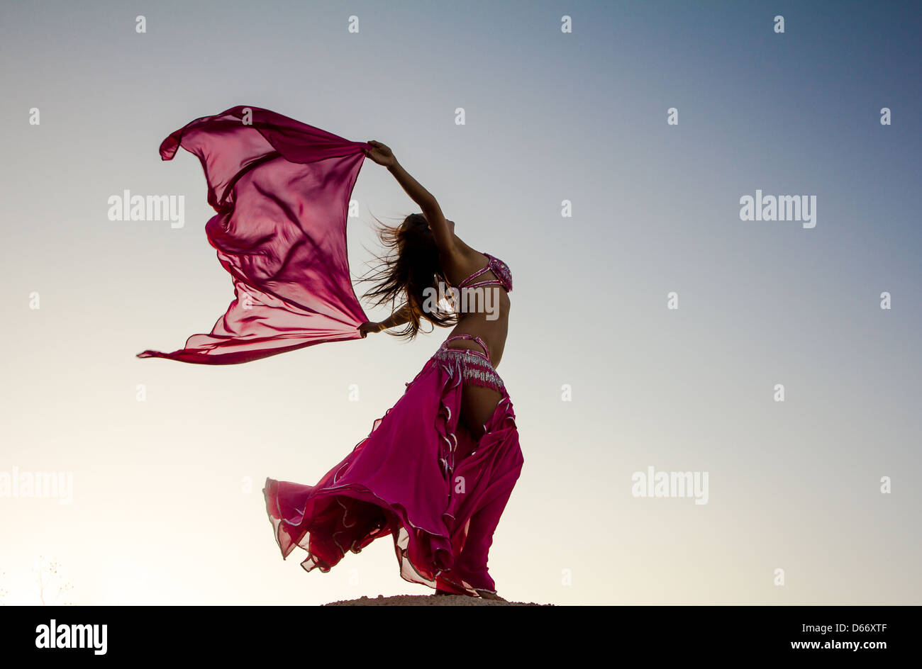 Pretty girl holding pink cloth in wind with sky background Stock Photo ...