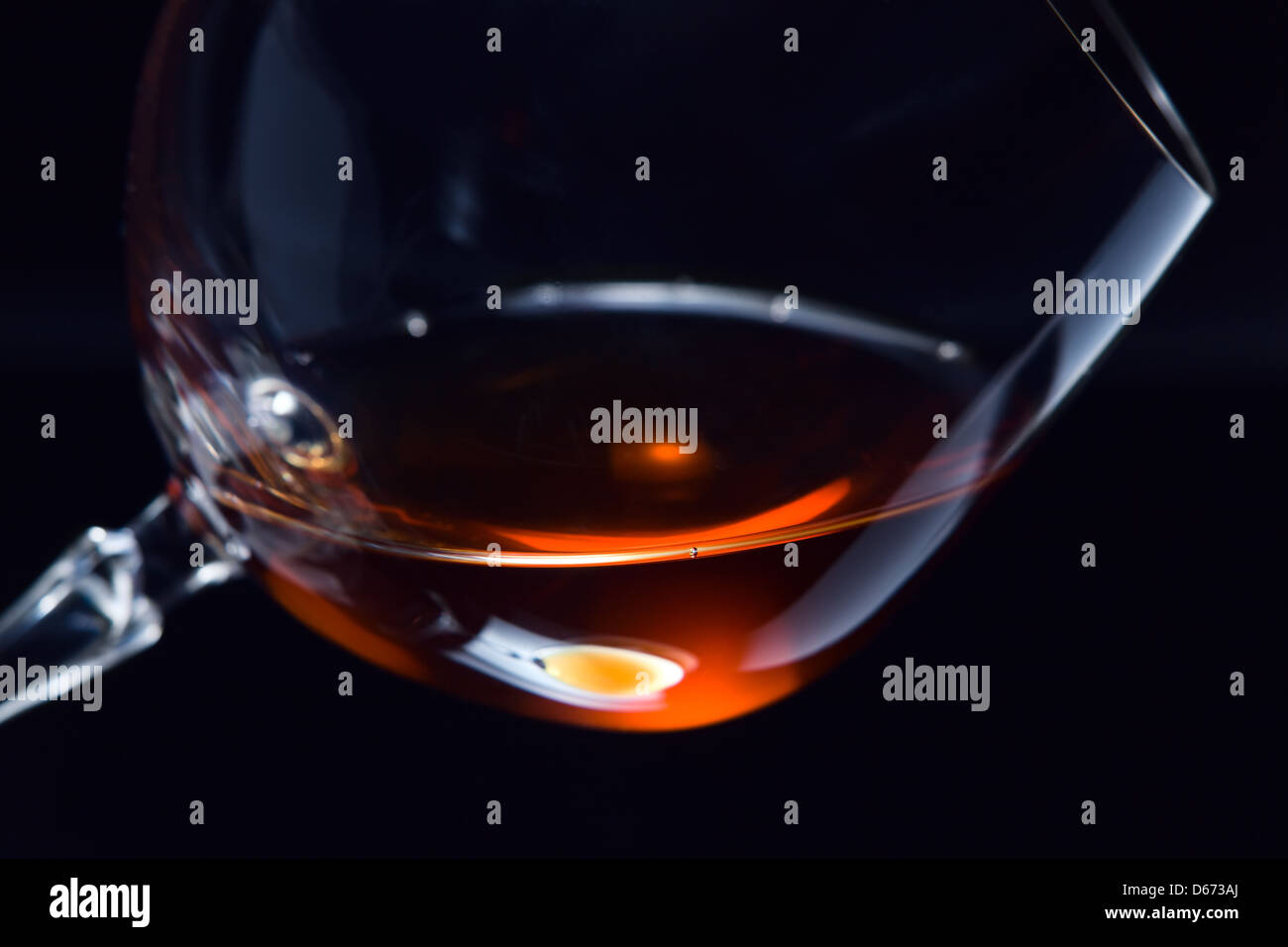 snifter with brandy on a dark background Stock Photo - Alamy