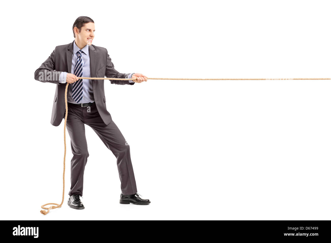 Full length portrait of a young businessman in suit pulling a rope ...