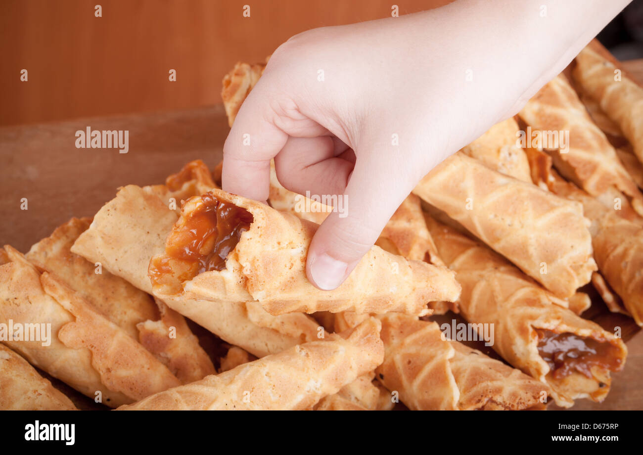 Homemade wafer cone with cream of sweet boiled condensed milk in girl's ...