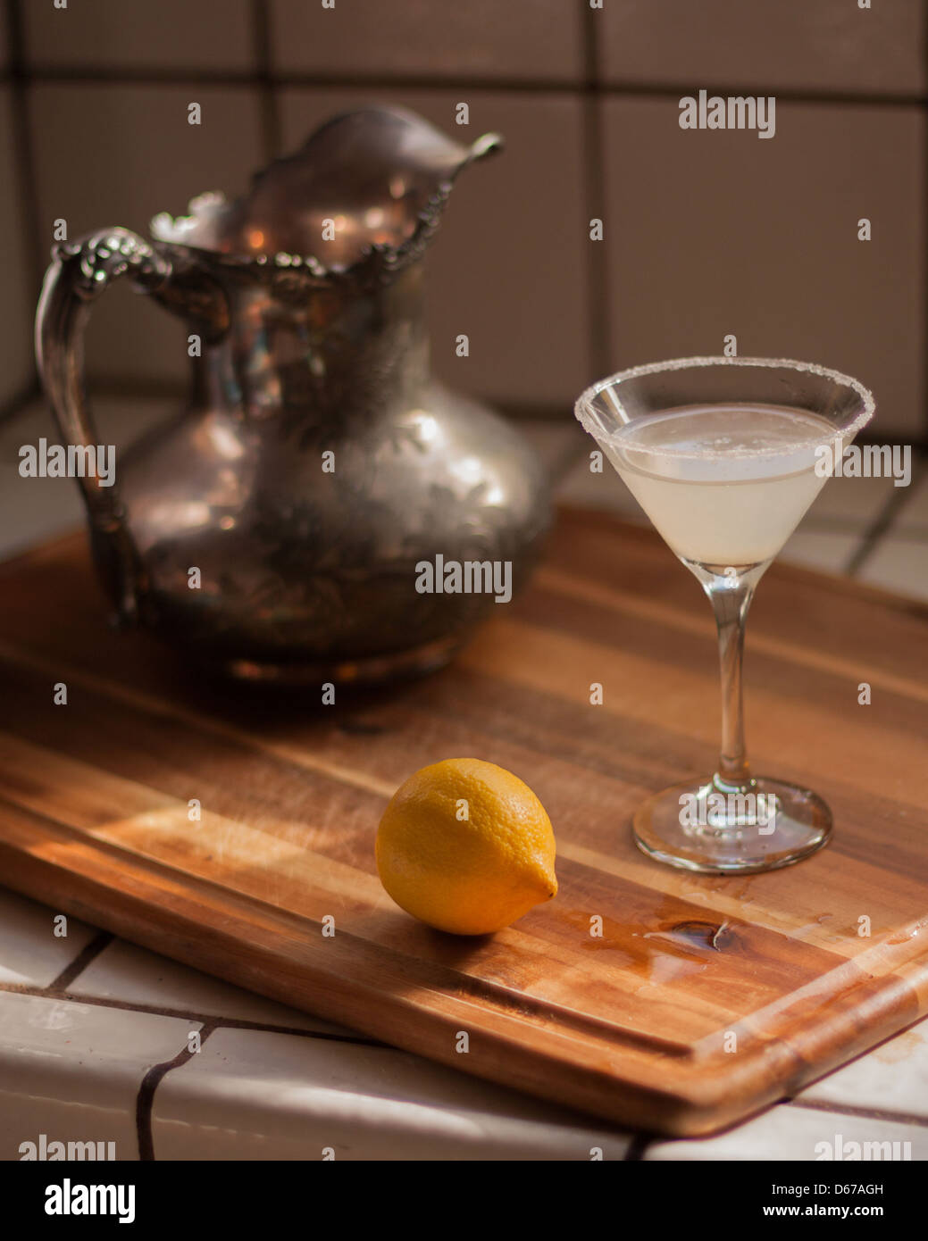 An old fashioned lemon drop on the counter with a lemon and silver ...