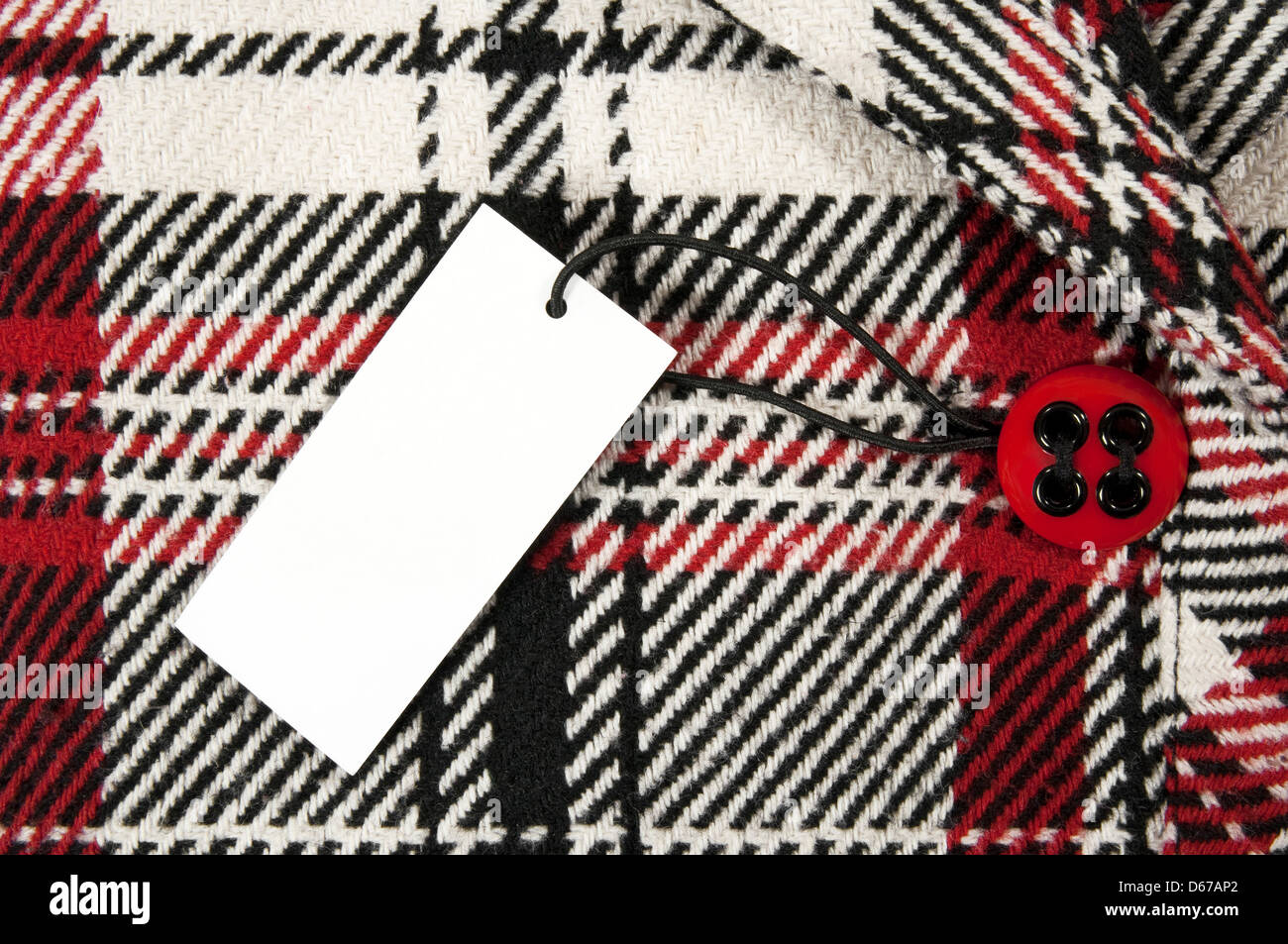 Blank price tag attached to a button of a stylish red checked coat ...