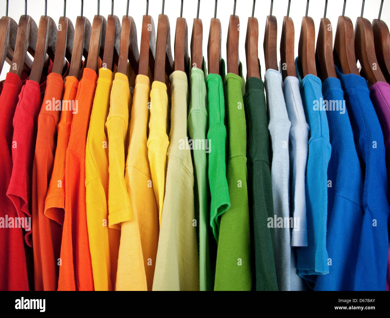 Colors of rainbow. Variety of casual clothes on wooden hangers ...