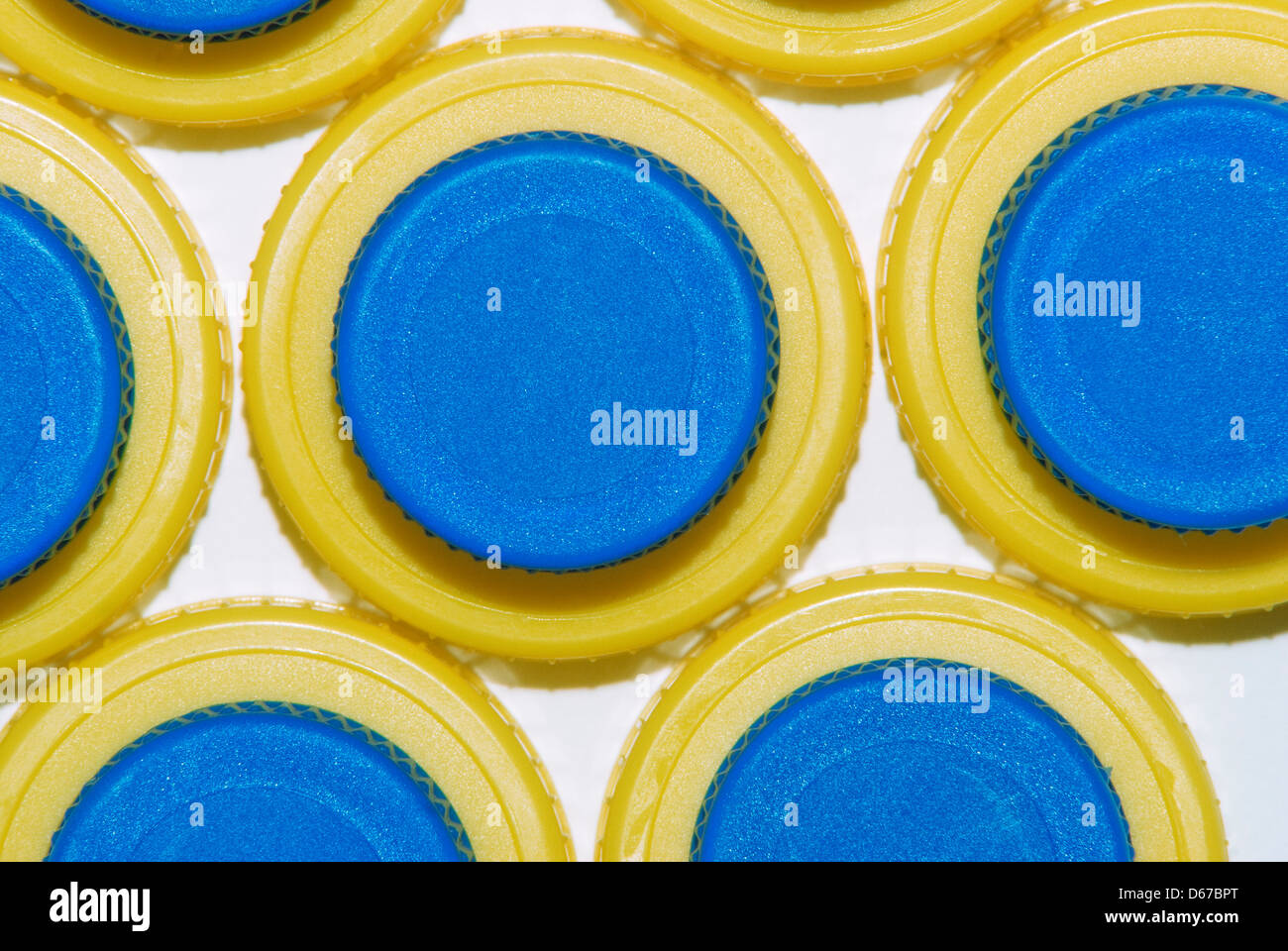 plastic caps of blue and yellow on white background Stock Photo - Alamy