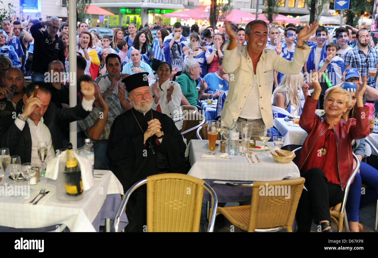 Greek Orthodox Archpriest Apostolos Malamoussis (2-L) watches the UEFA ...
