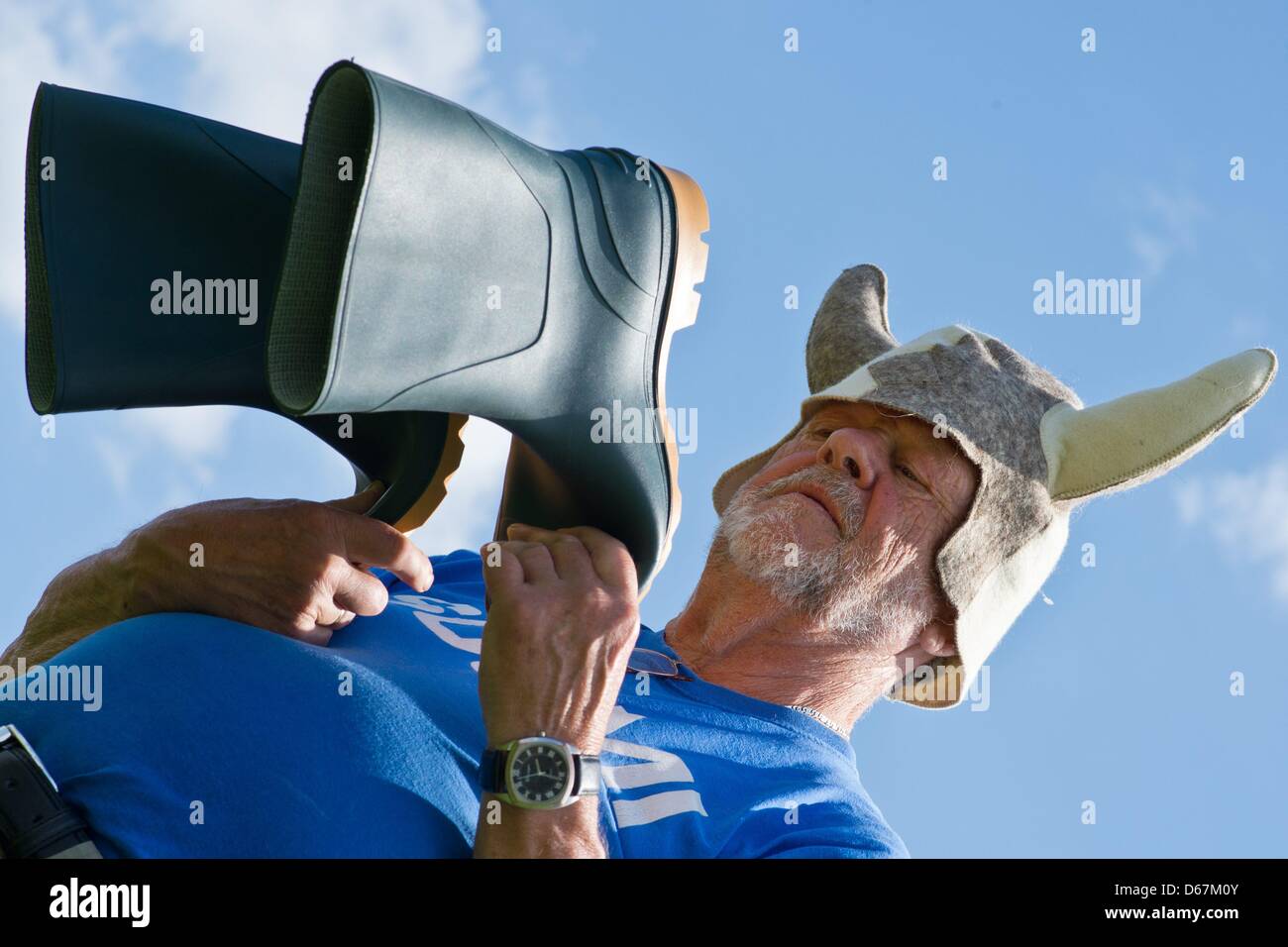 A participant checks his boots during the rubber boot throwing ...