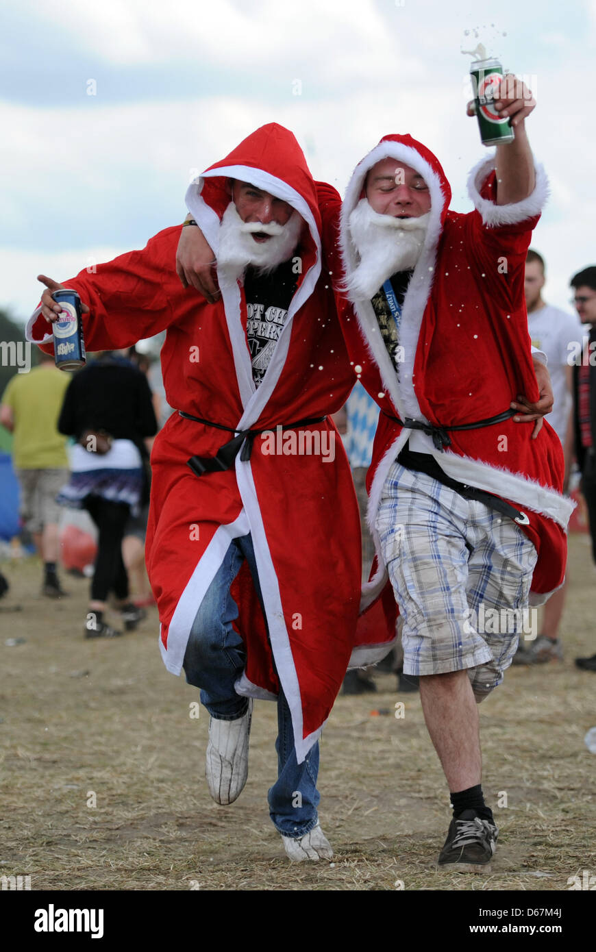 Two festival visitors dressed as Santa Claus celebrate at the Hurricane ...
