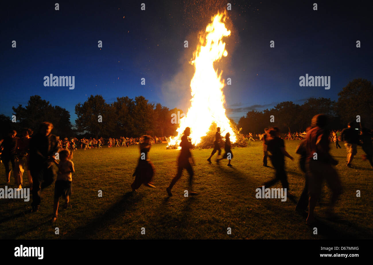 Visitors dance around a midsummer fire in Freiburg, Germany, 23 June ...