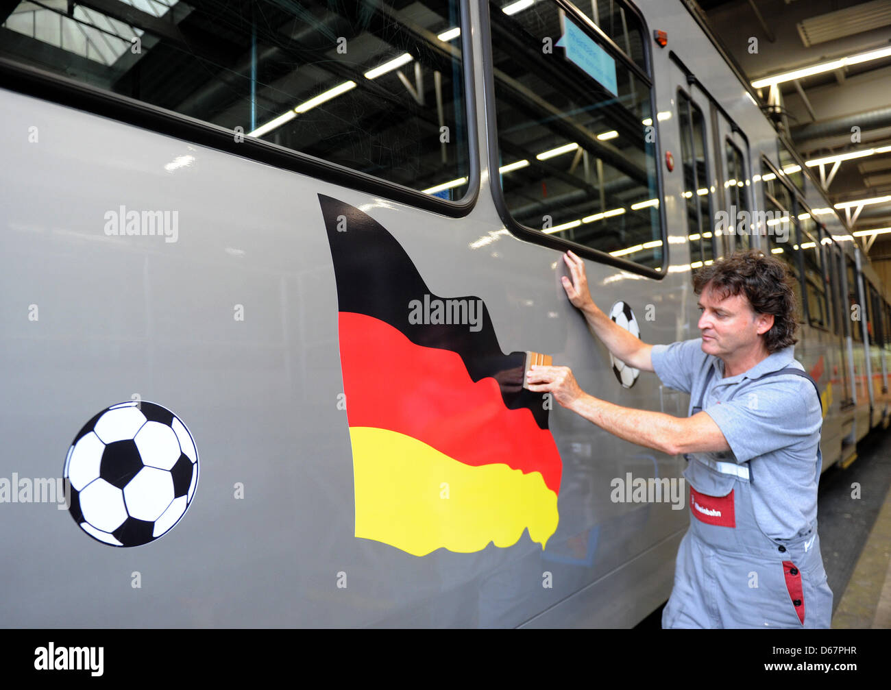 Painter Manfred Schnitzler glues a german flag and a soccer ball ...