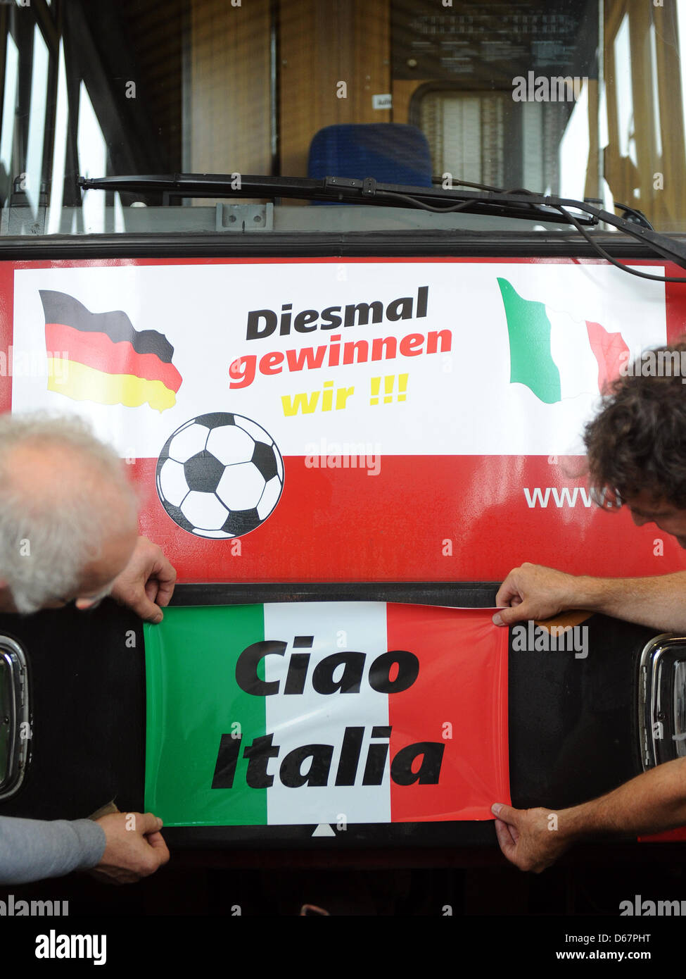 Painter Manfred Schnitzler (R) and Werner Heinisch glue a sticker ...