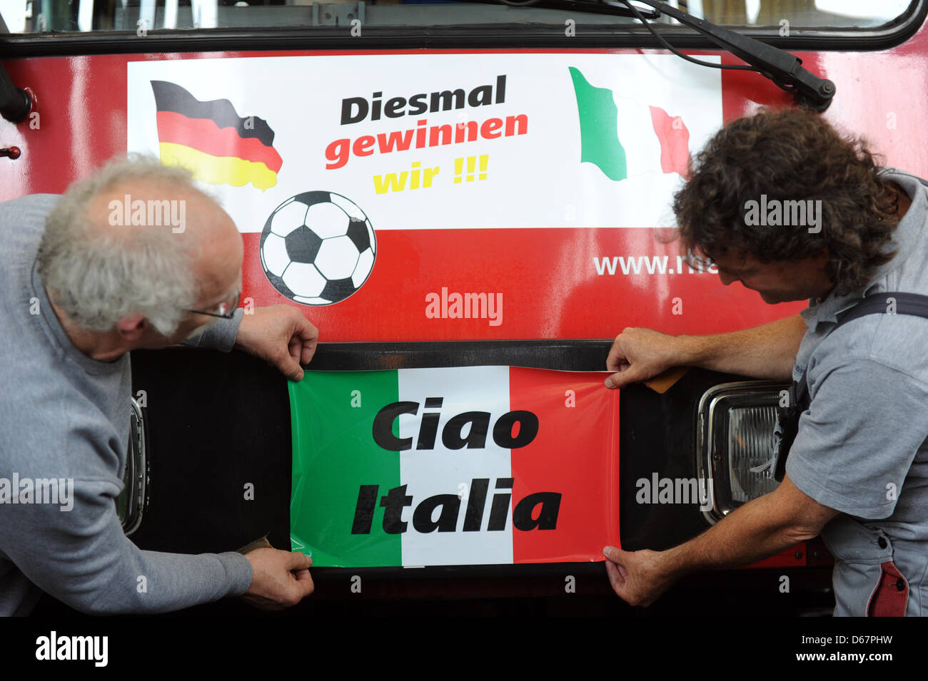 Painter Manfred Schnitzler (R) and Werner Heinisch glue a sticker ...