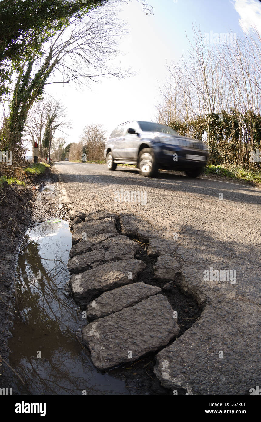 Potholes in country road caused by snow and freezing weather melting ...