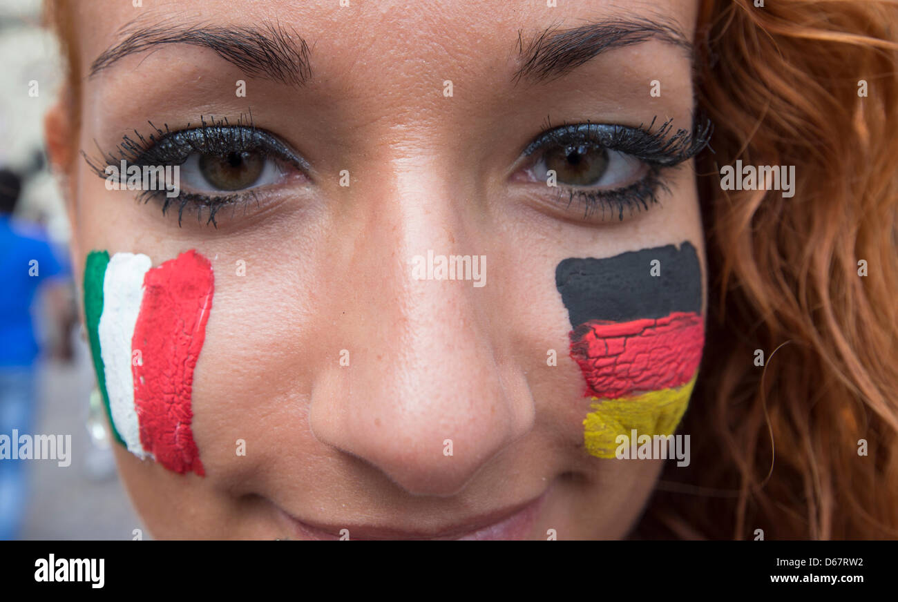 A female supporter with a German and an Italian flag on her face in ...