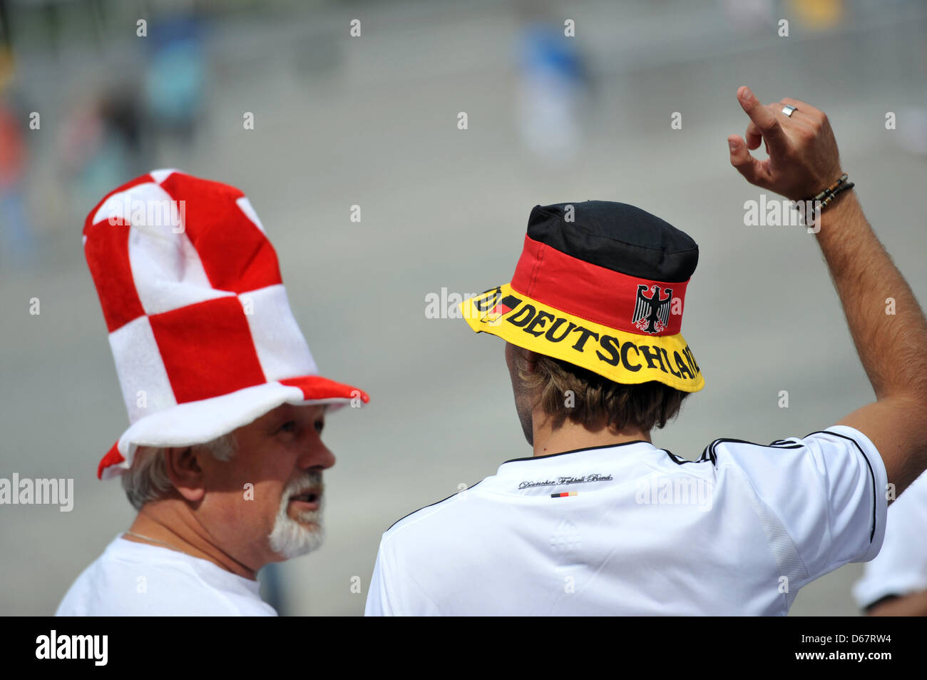 A German fan and a supporter of the Polish team walk through the fan ...