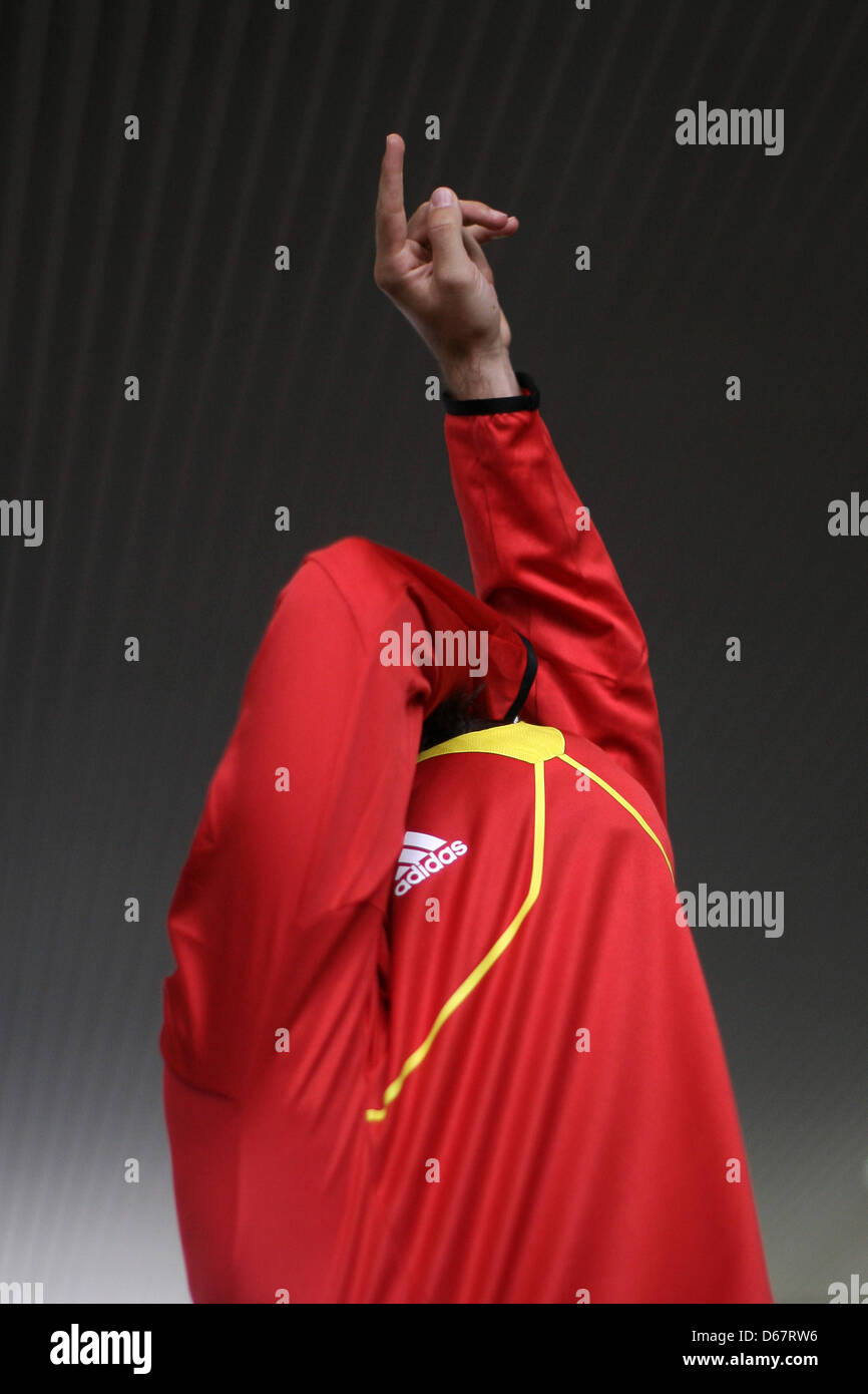 Table tennis player Timo Boll puts on a T-shirt of the Olympic uniform ...